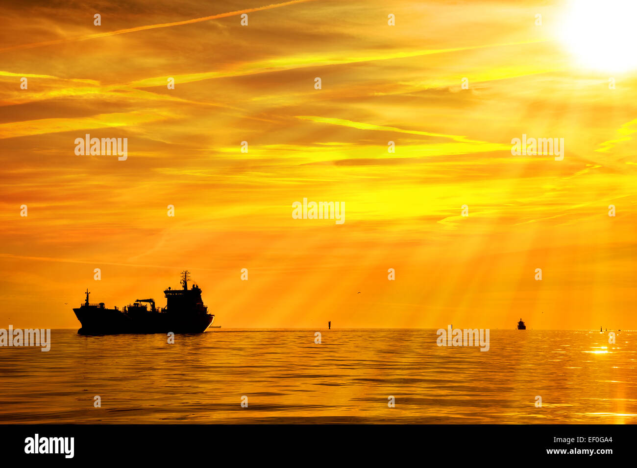 Cargo ship on sea in the rays of the setting sun Stock Photo - Alamy