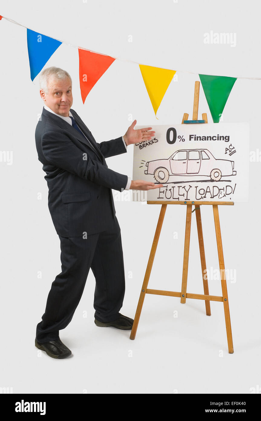 Salesman standing beside a car ad Stock Photo - Alamy