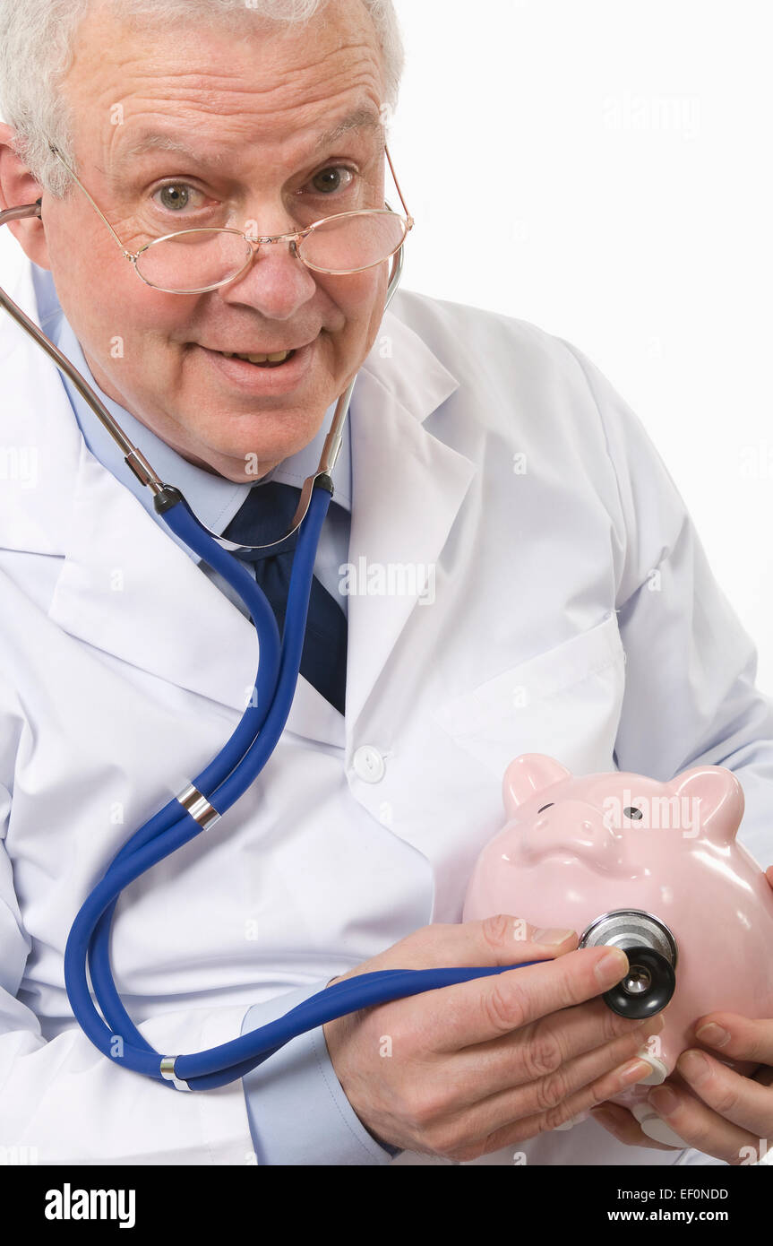 Doctor putting stethoscope on piggy bank Stock Photo - Alamy