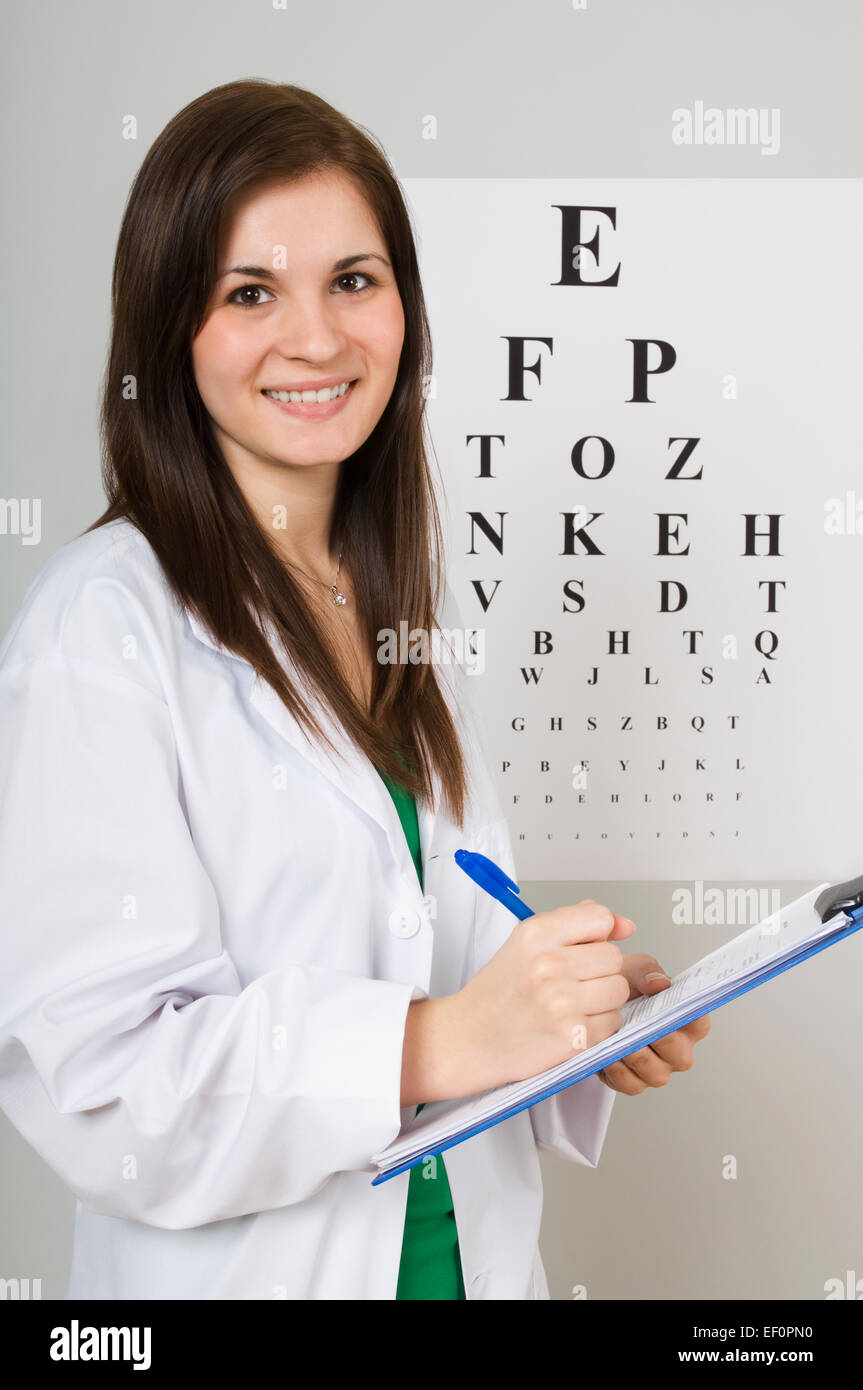 Optometrist writing on chart Stock Photo - Alamy
