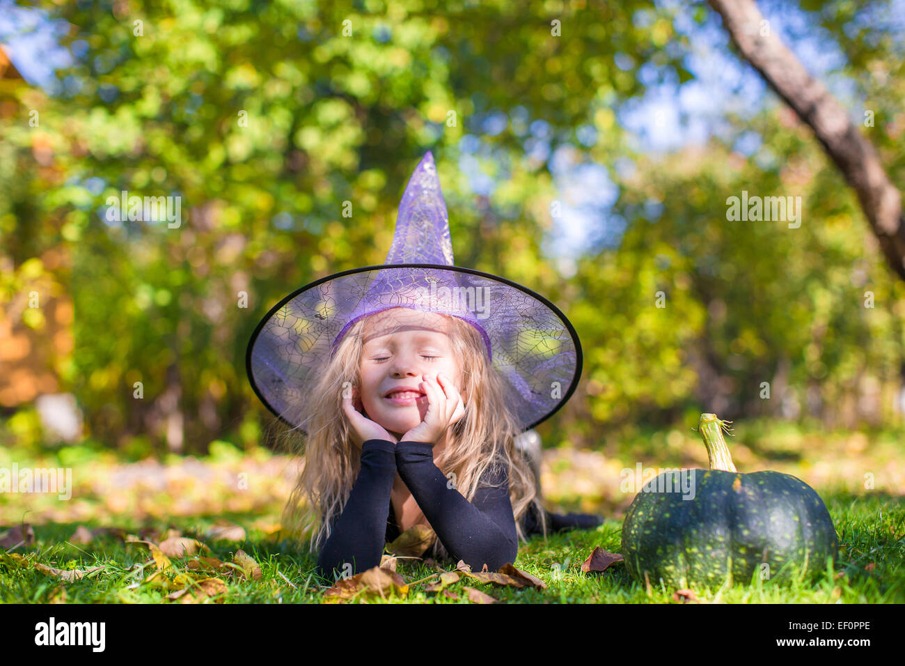 Cute little girl in Halloween costume with jack pumpkin Stock Photo - Alamy