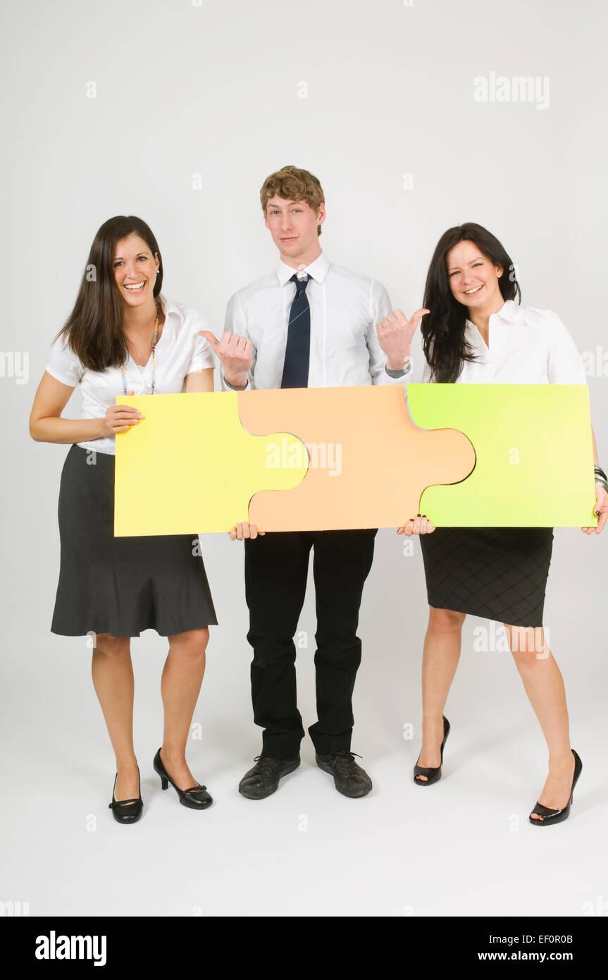 Three people putting puzzle pieces together Stock Photo - Alamy