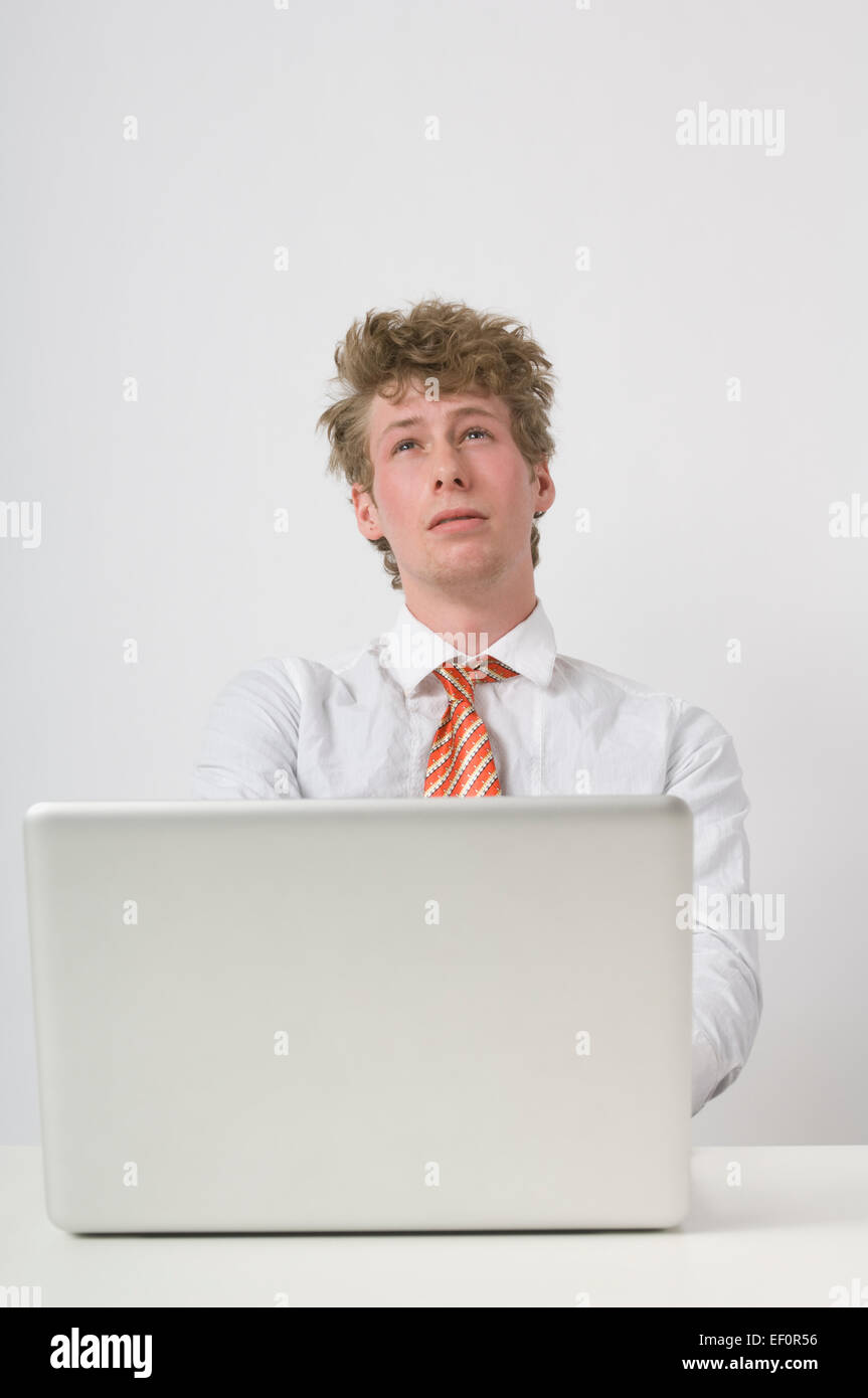 Man daydreaming while sitting at desk Stock Photo - Alamy