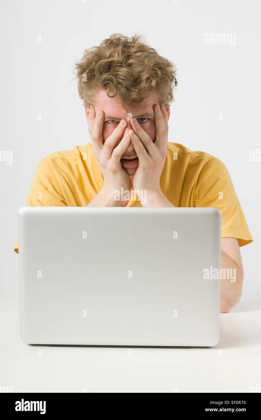 Frustrated man sitting at desk Stock Photo - Alamy