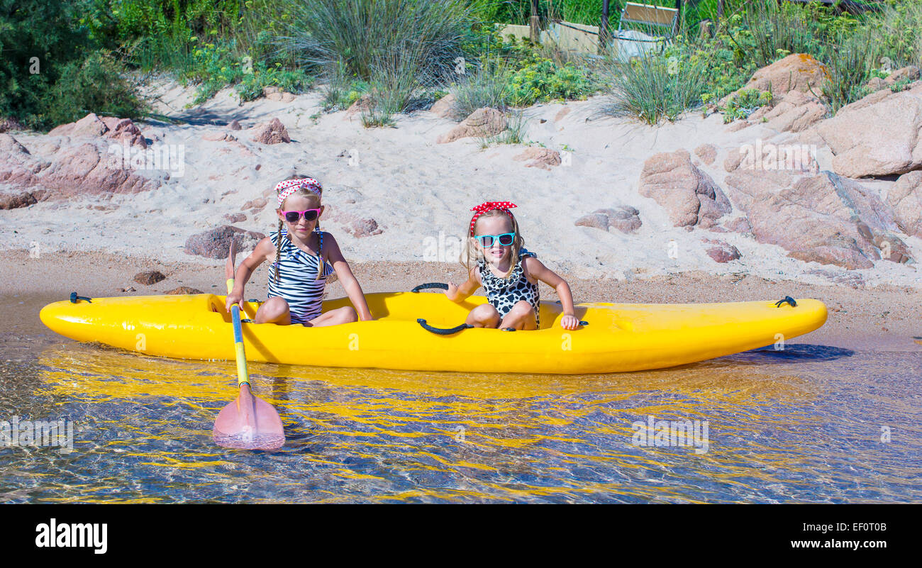 Little adorable girls enjoying kayaking in the clear turquoise water ...