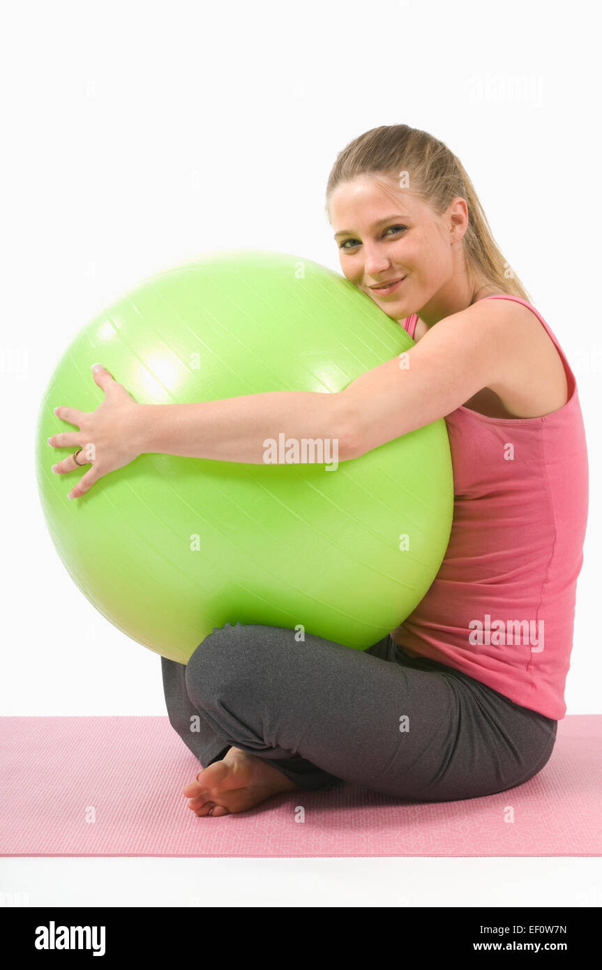 Woman hugging exercise ball Stock Photo - Alamy