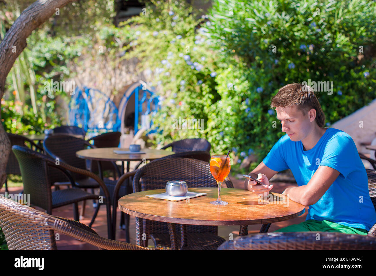 Young man in outdoor cafe talking on phone Stock Photo - Alamy
