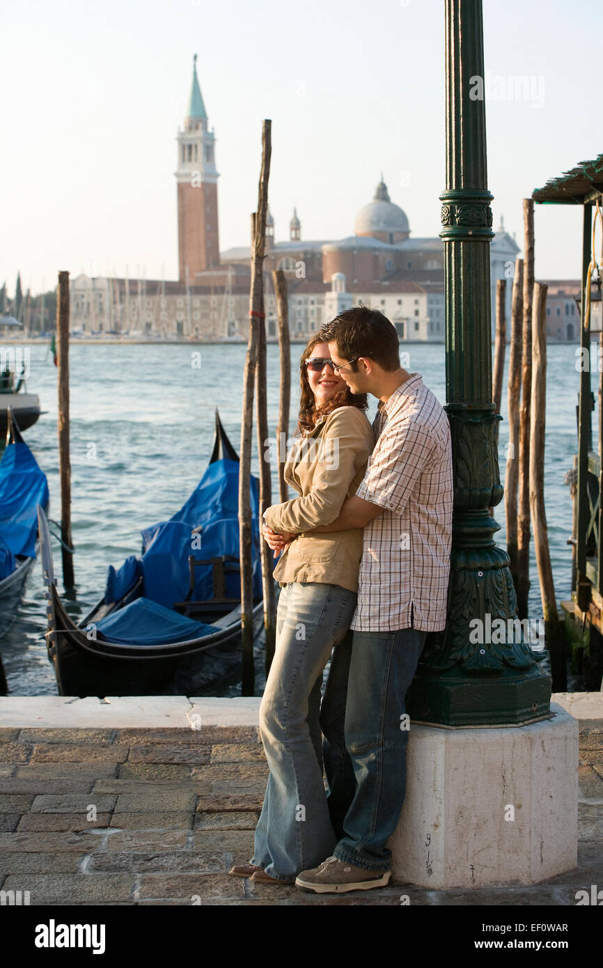 Couple leaning against light poll hugging in Venice Italy Stock Photo ...