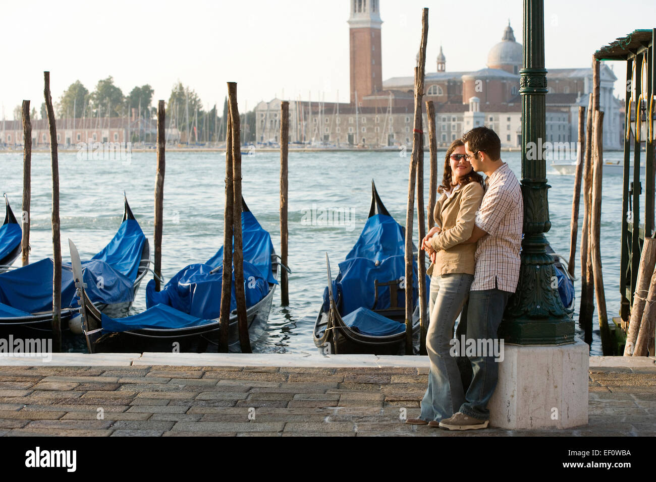 Couple leaning against light poll hugging in Venice Italy Stock Photo ...
