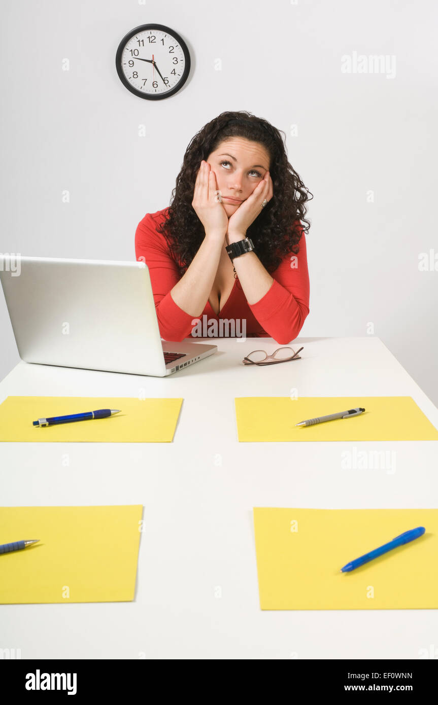 Bored woman waiting at desk Stock Photo - Alamy
