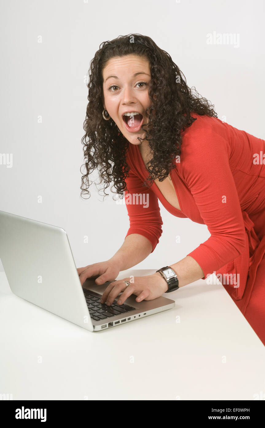Excited woman typing on laptop Stock Photo - Alamy