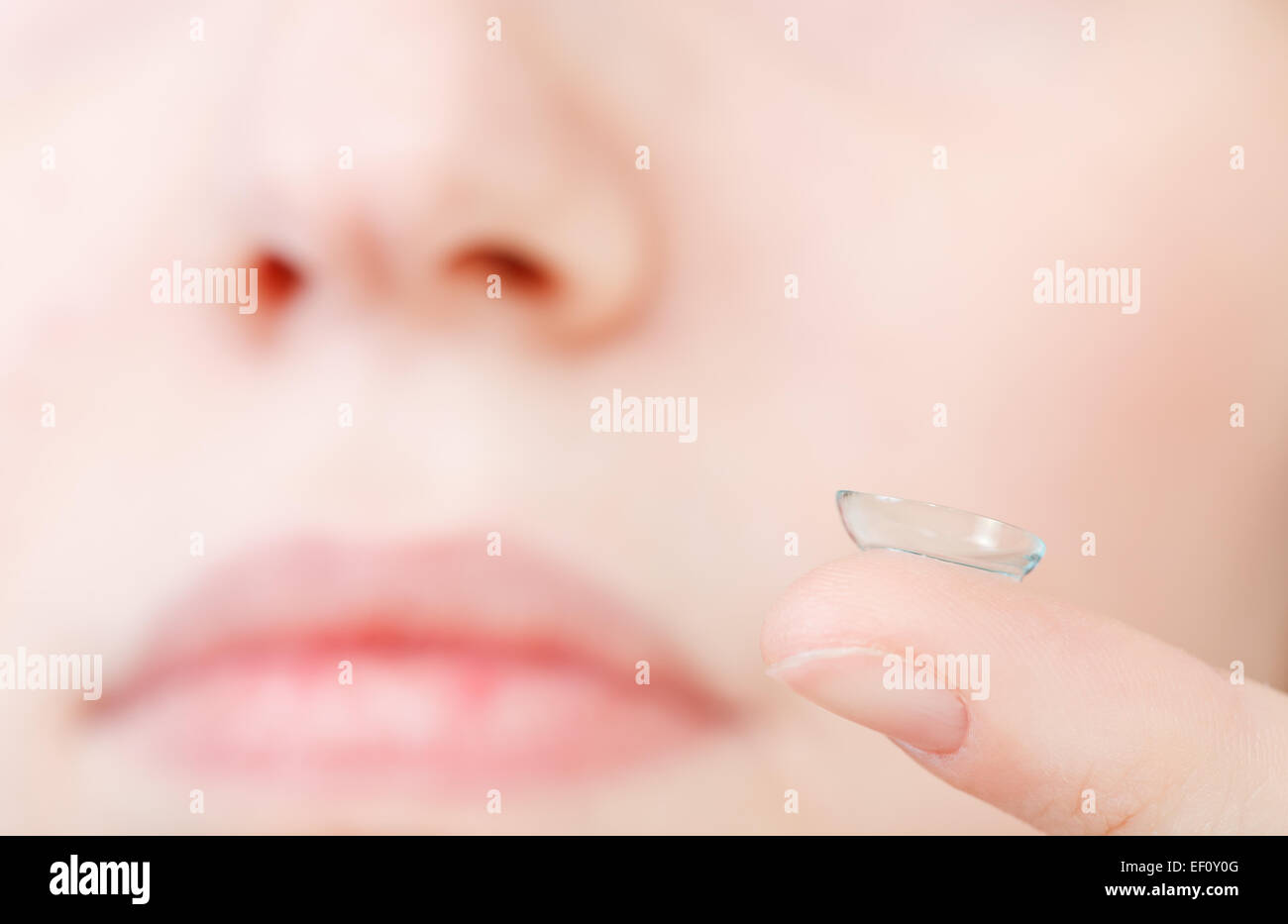 corrective lens on finger near female face close up Stock Photo - Alamy