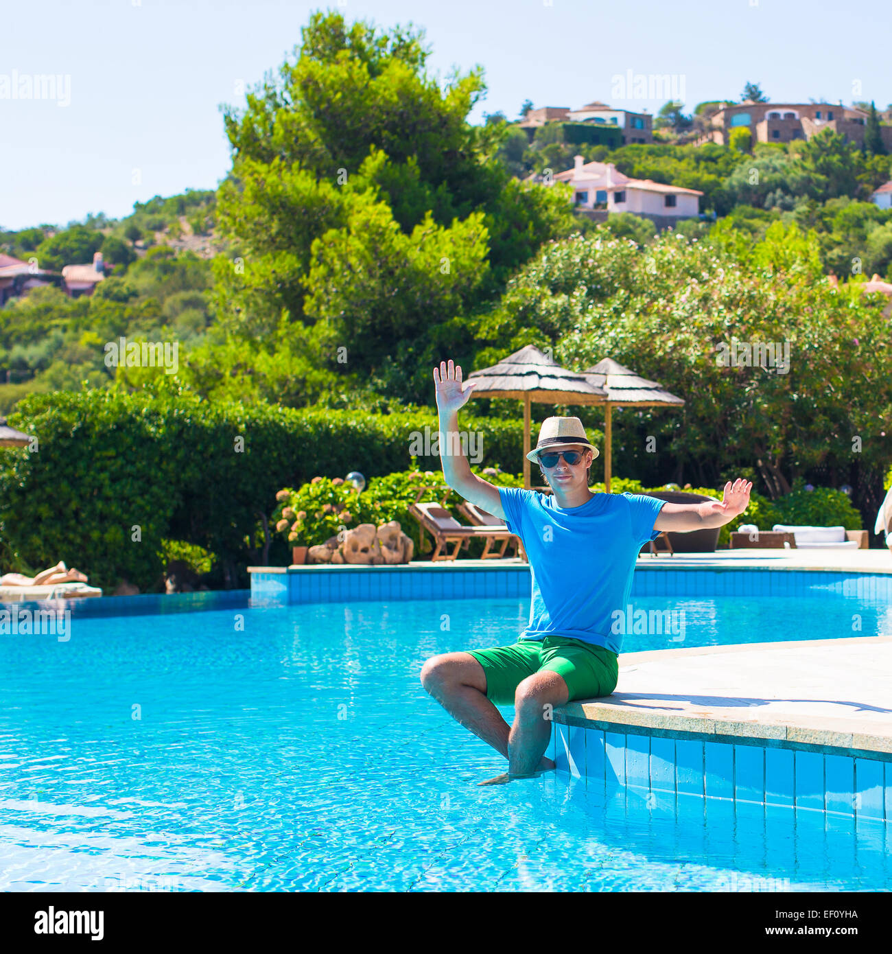 Happy man relaxing by swimming pool Stock Photo - Alamy