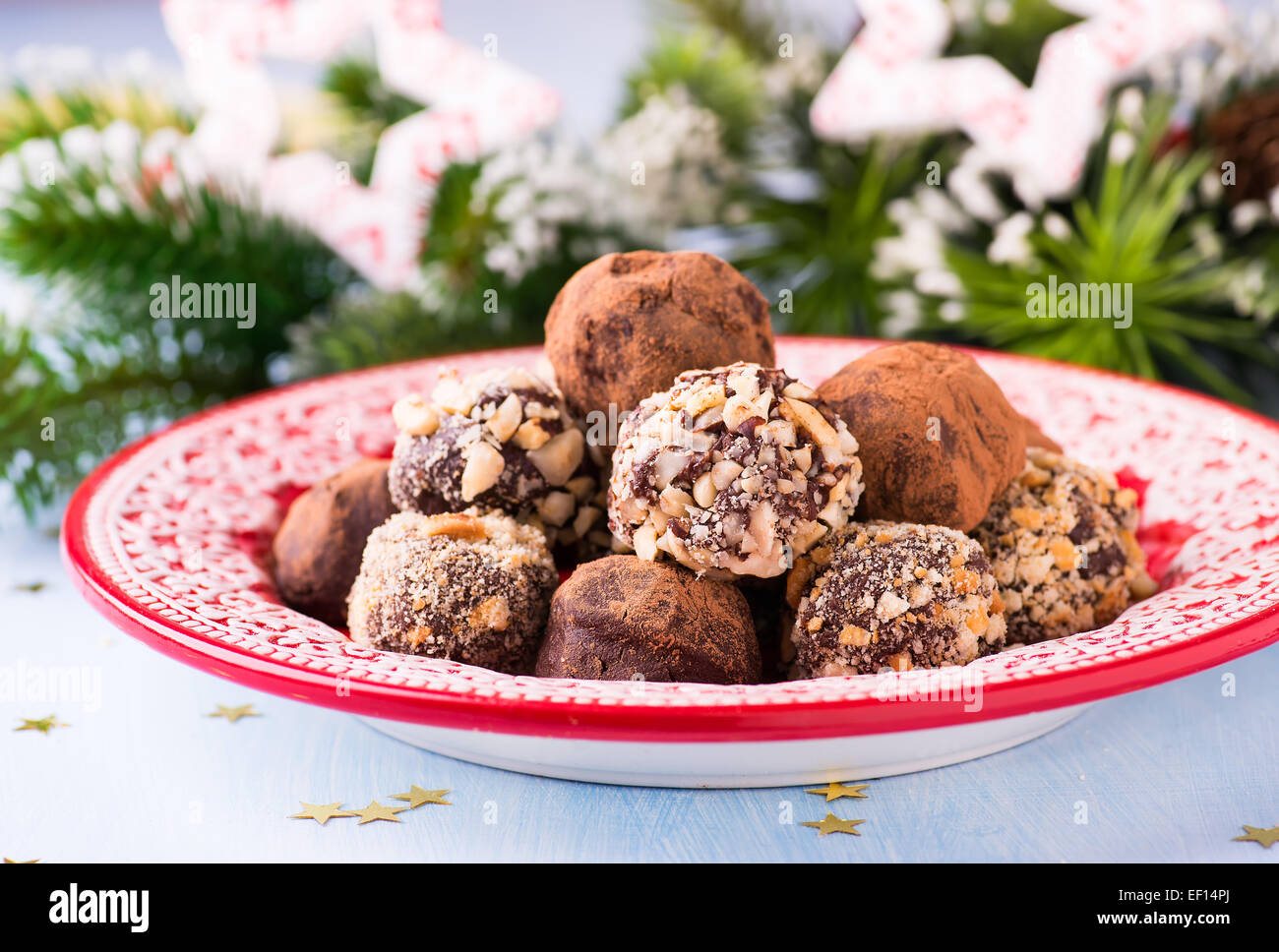 Assorted dark chocolate truffles on red plate, festive decorations ...