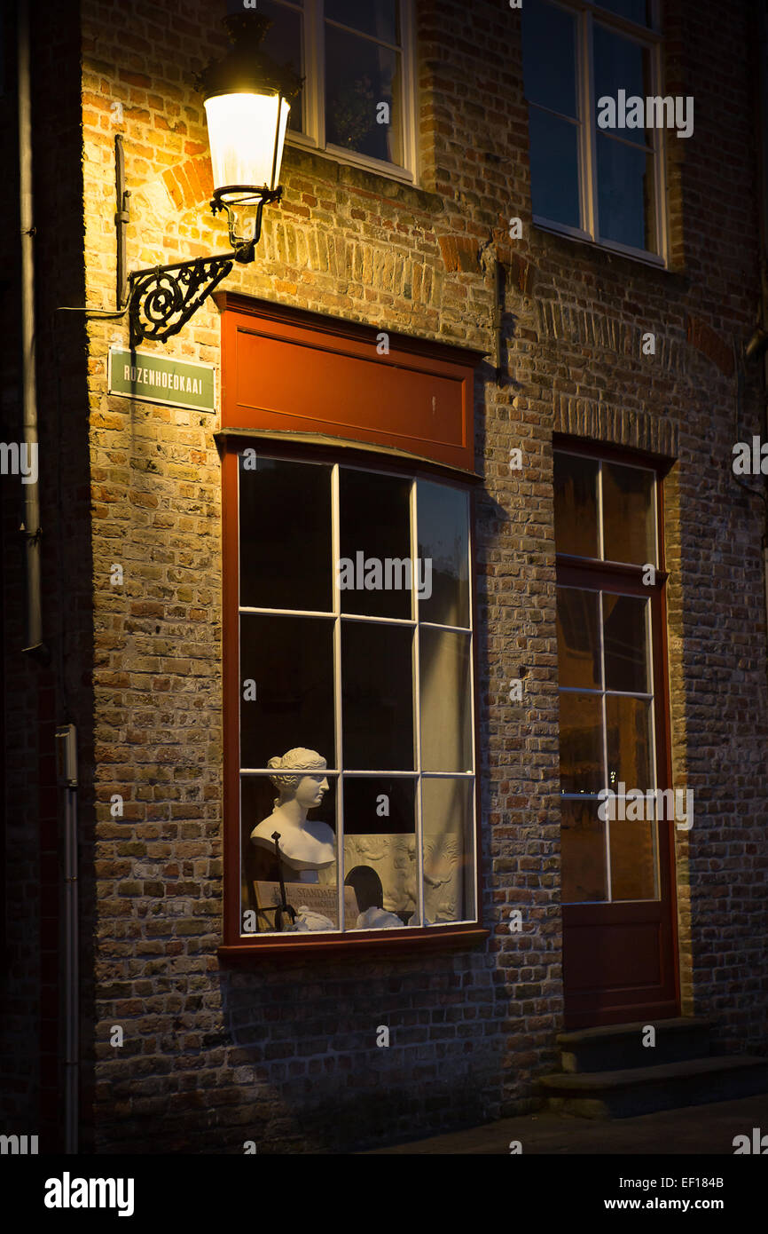 Female bust in a window at night under Rozenhoedkaai street sign ...