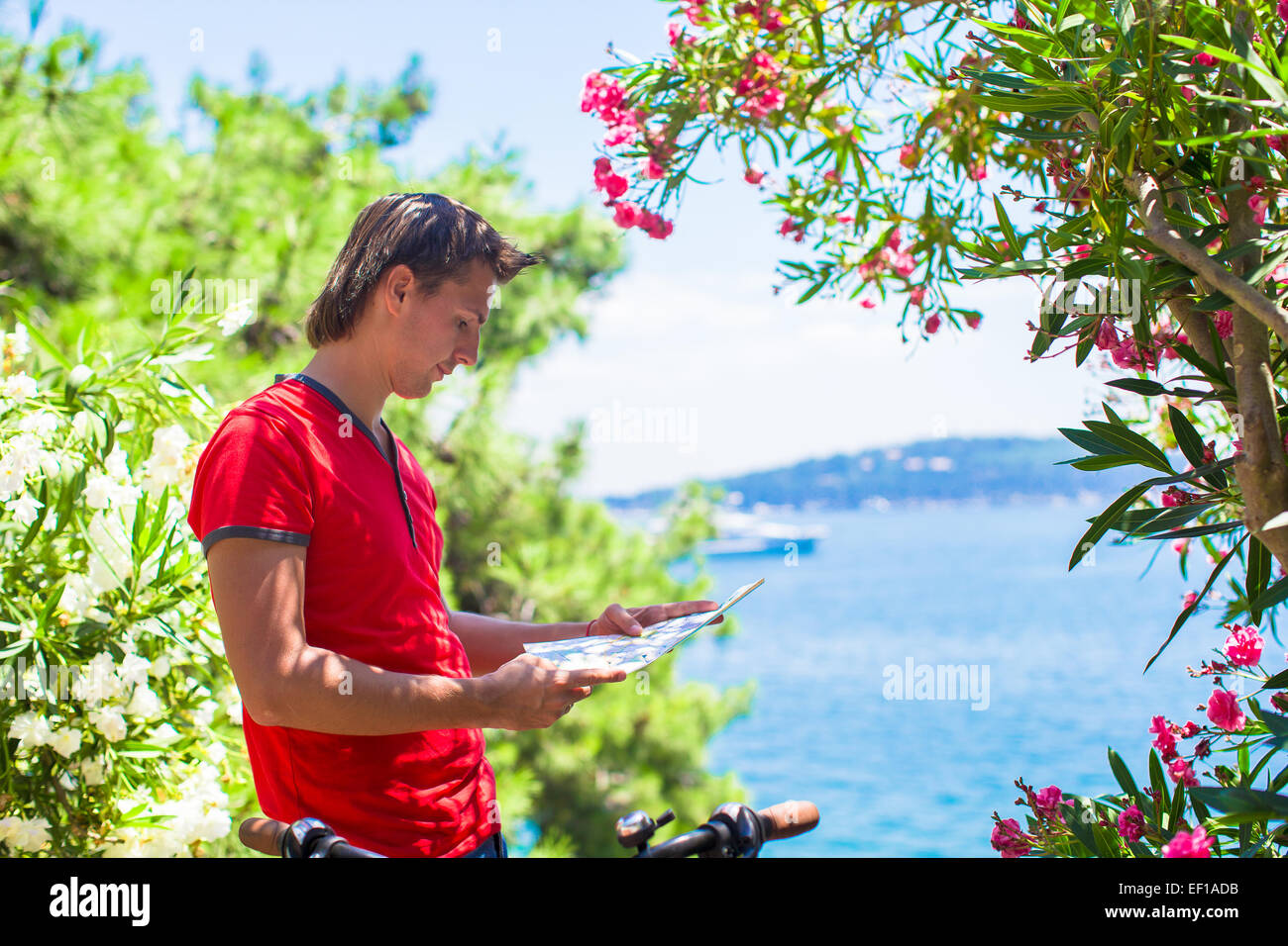 Young traveling man with map while exploring island Stock Photo - Alamy