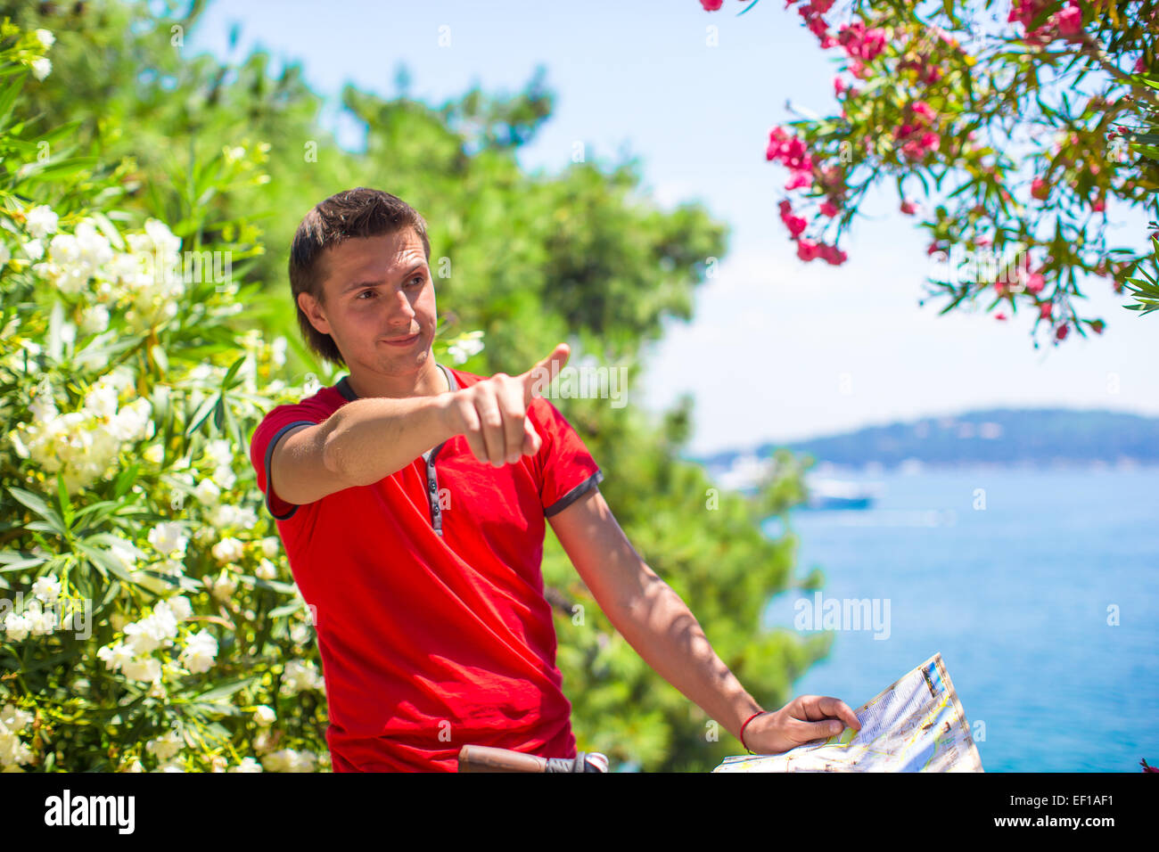 Portrait of young traveling man with map while exploring island Stock ...