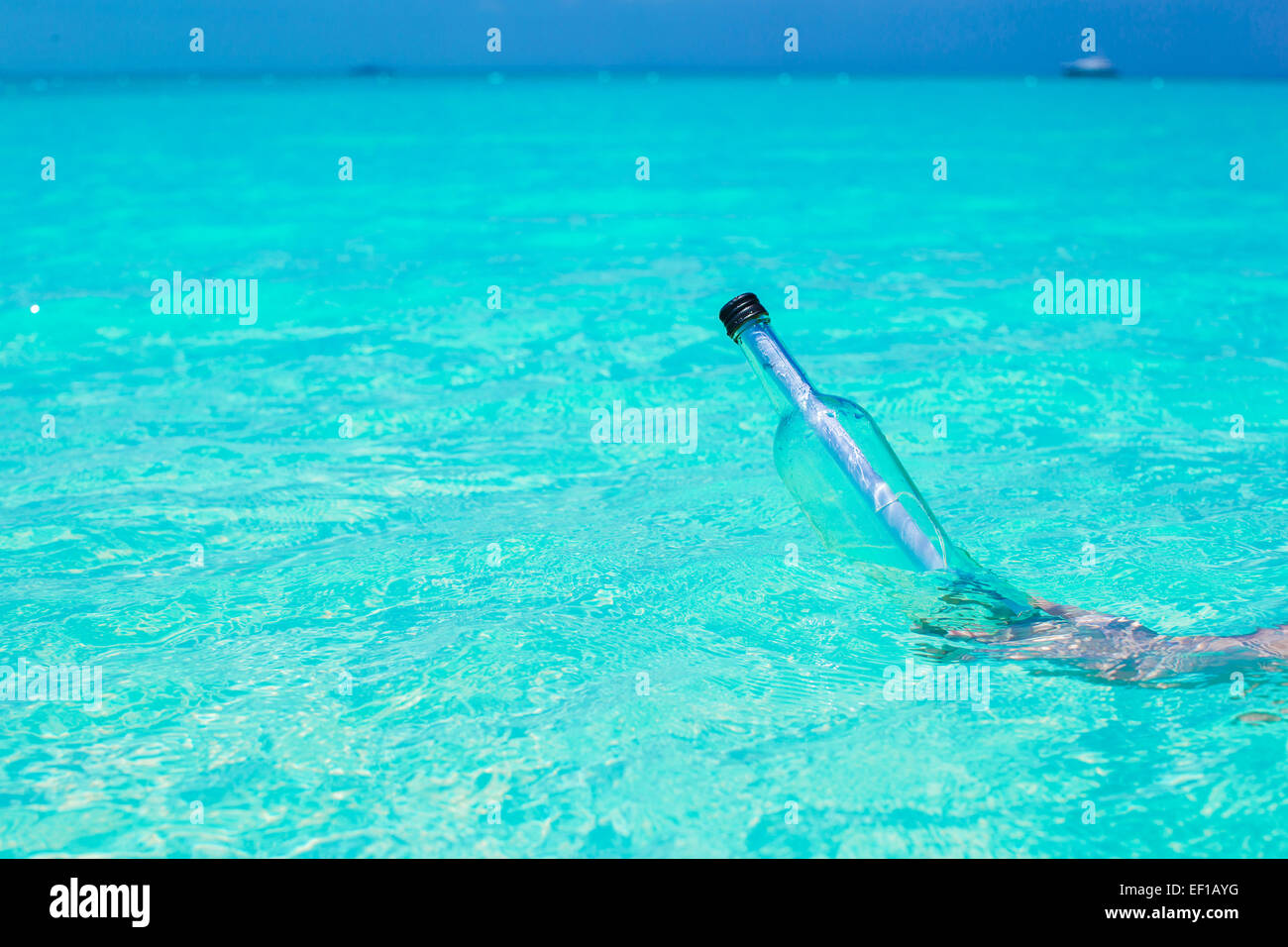 Bottle with a message in the hand background blue sky Stock Photo - Alamy