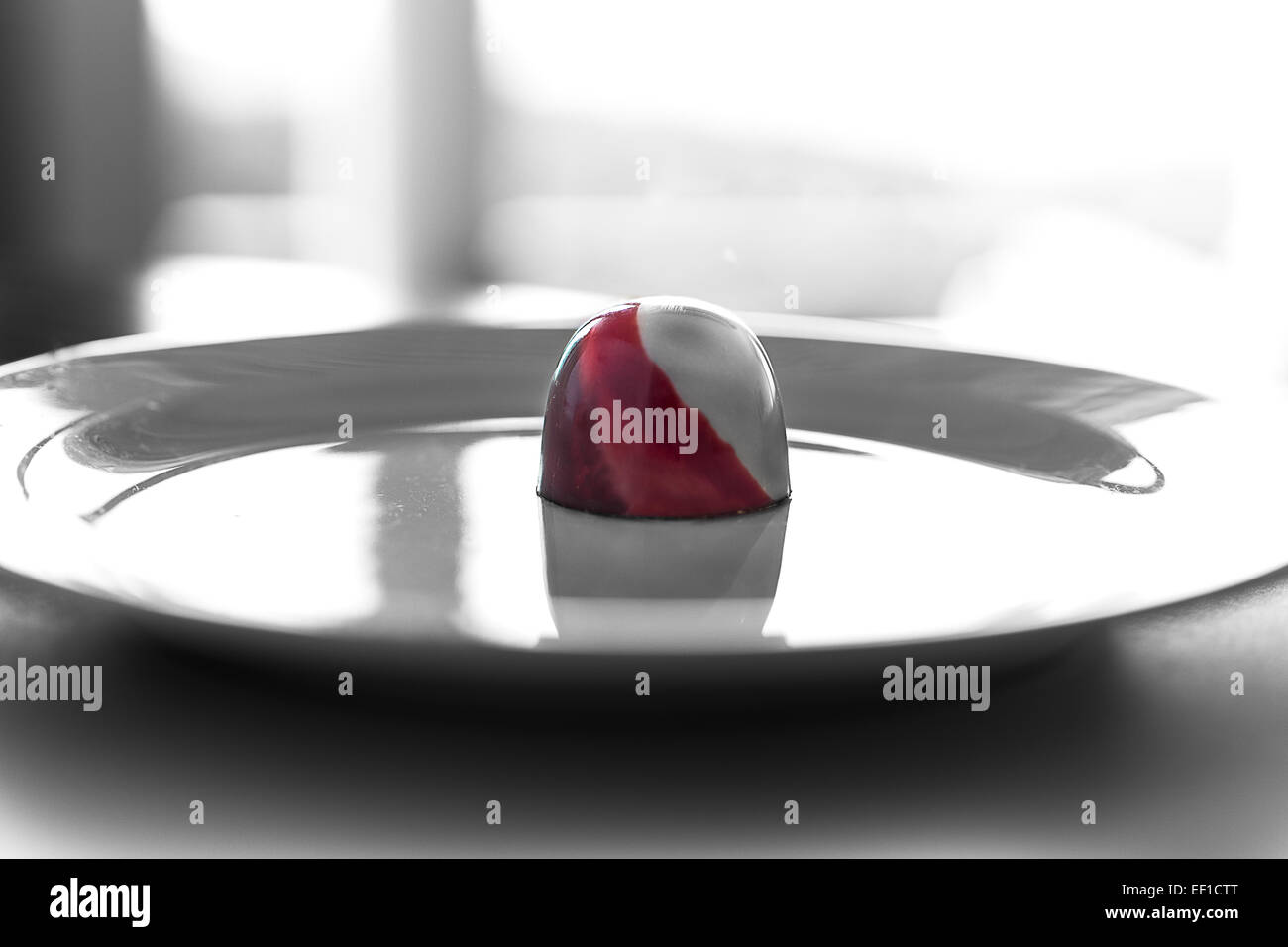 Single Red Chocolate on a plate Stock Photo - Alamy