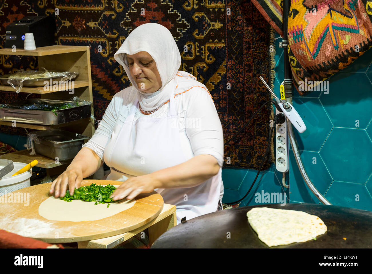 A Turkish woman preparing fresh feta gozleme at a street restaurant in ...
