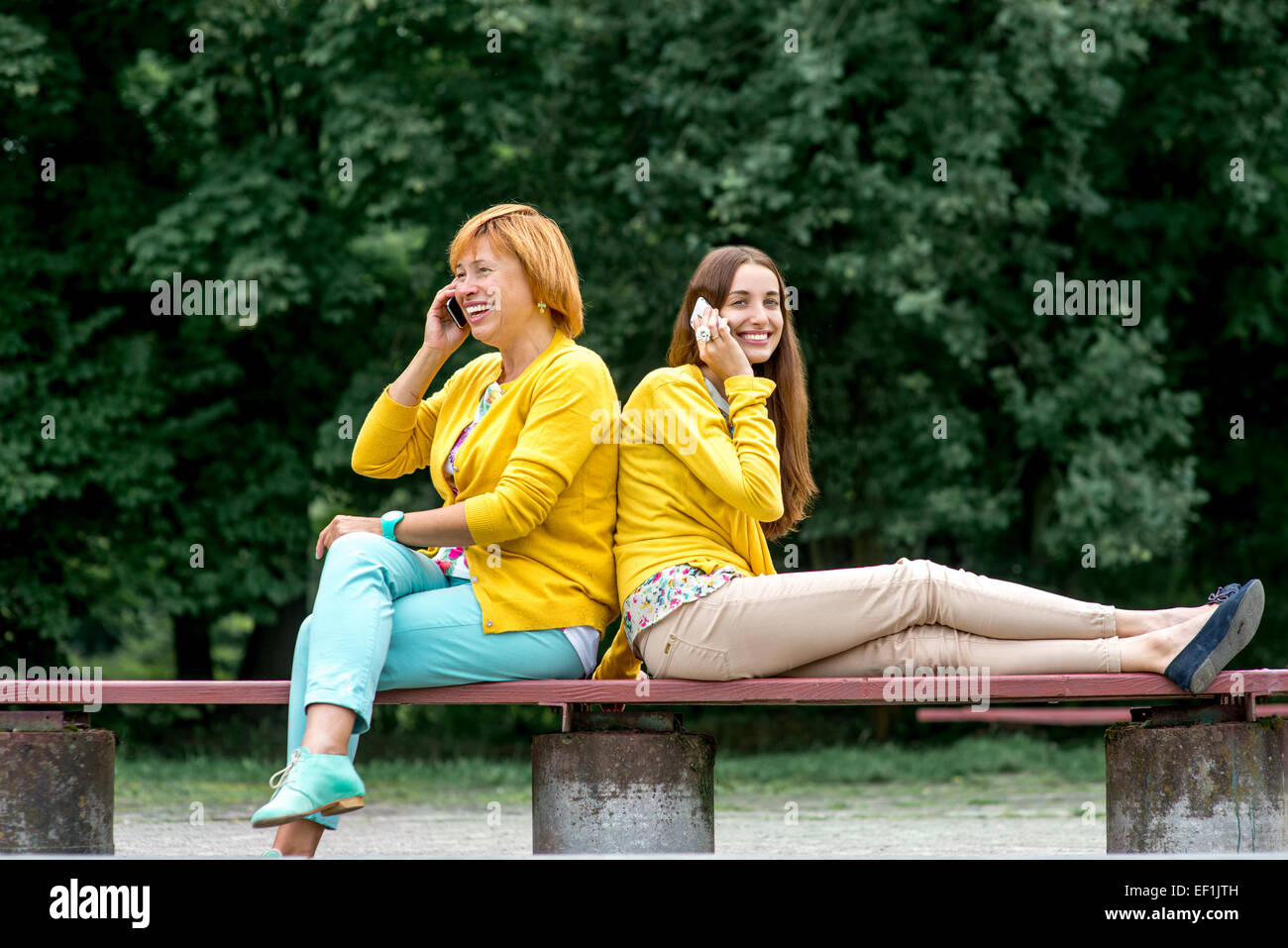 Mother talking with her daughter on the bench in the park Stock Photo ...