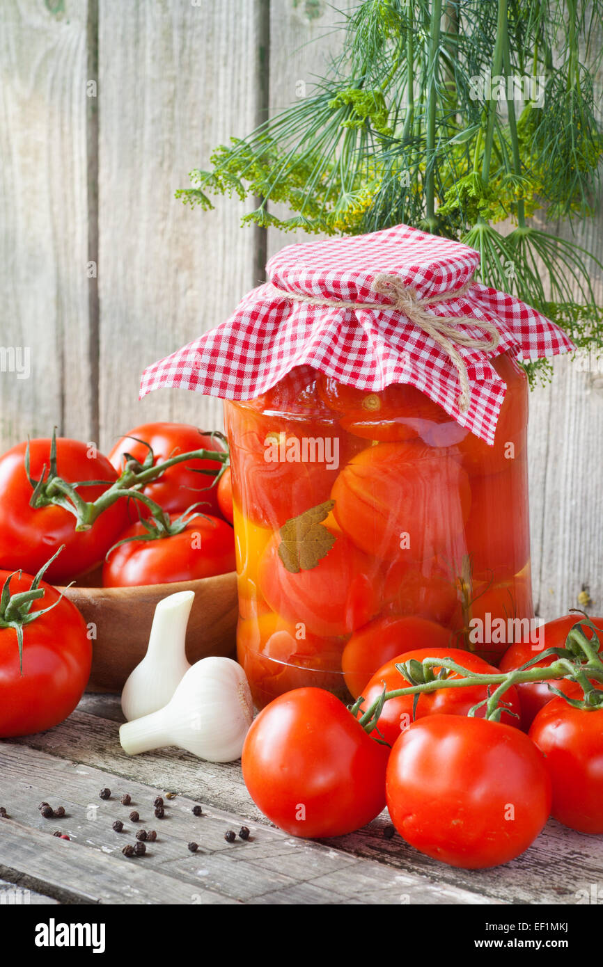 Homemade tomatoes preserves in glass jar. Fresh and canned tomatoes on ...