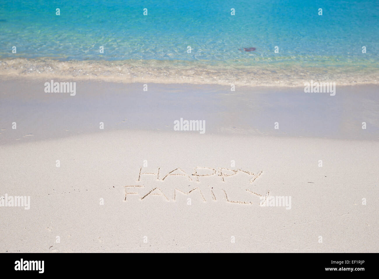 Happy family written on tropical beach white sand Stock Photo - Alamy