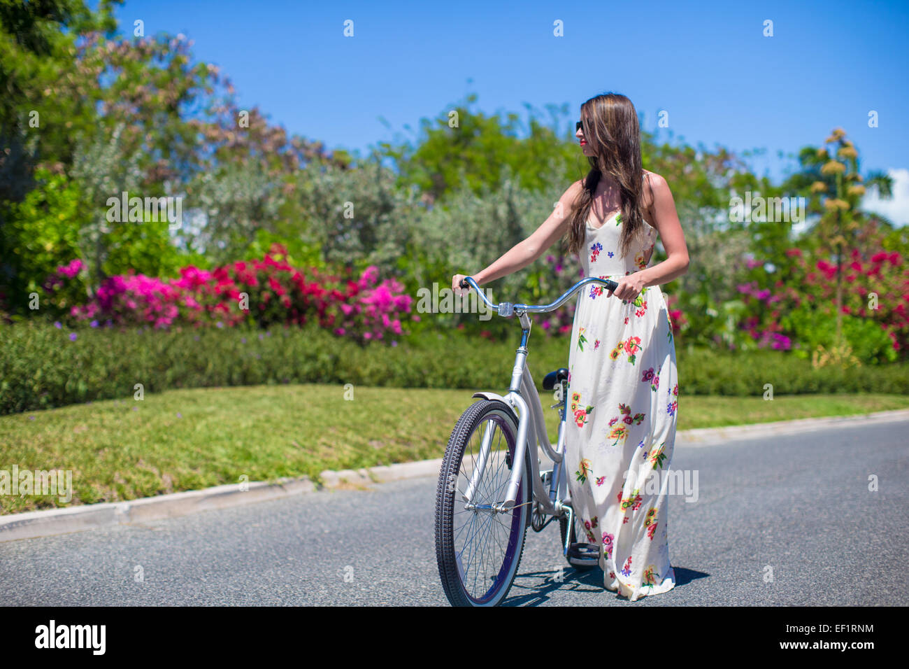 Young girl riding a bike on tropical resort Stock Photo - Alamy