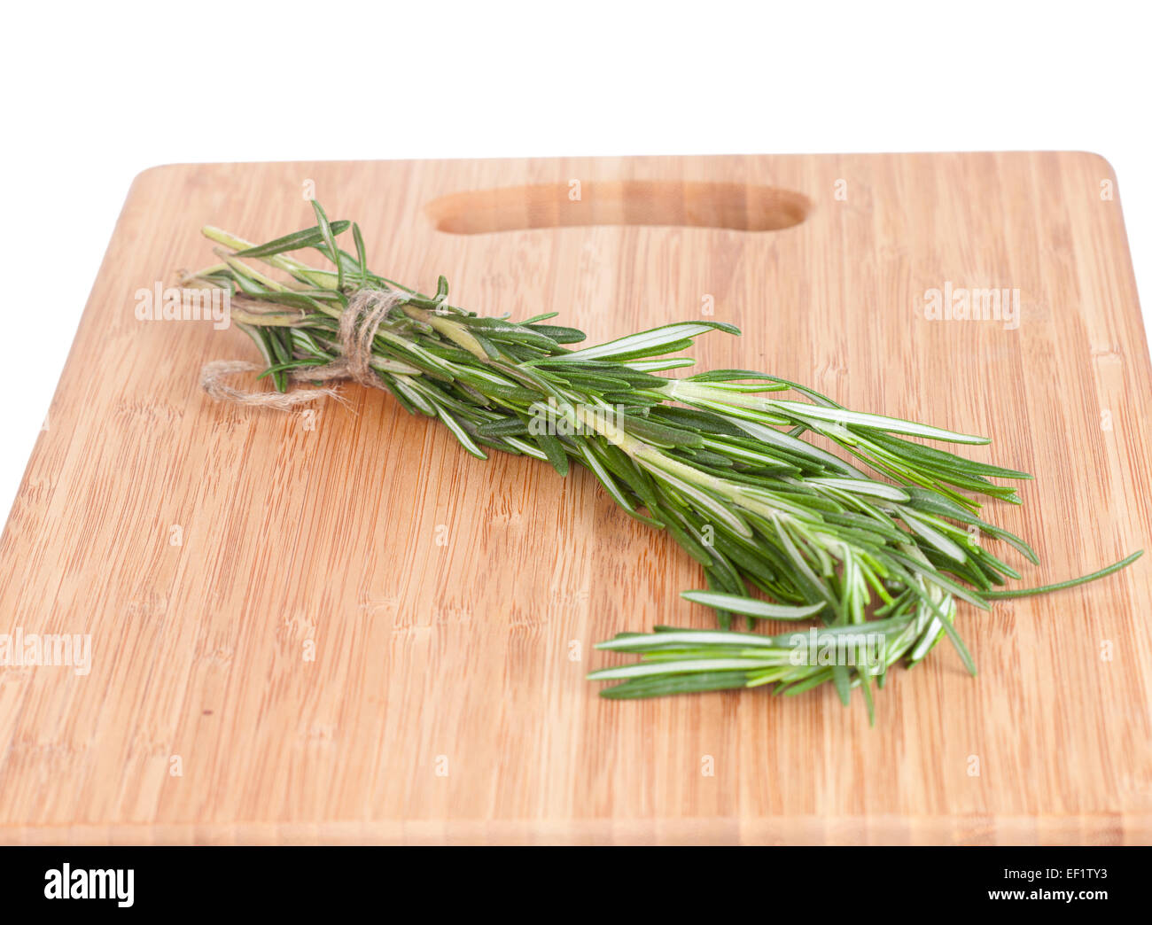 Rosemary branch on a chopping wooden board Stock Photo - Alamy