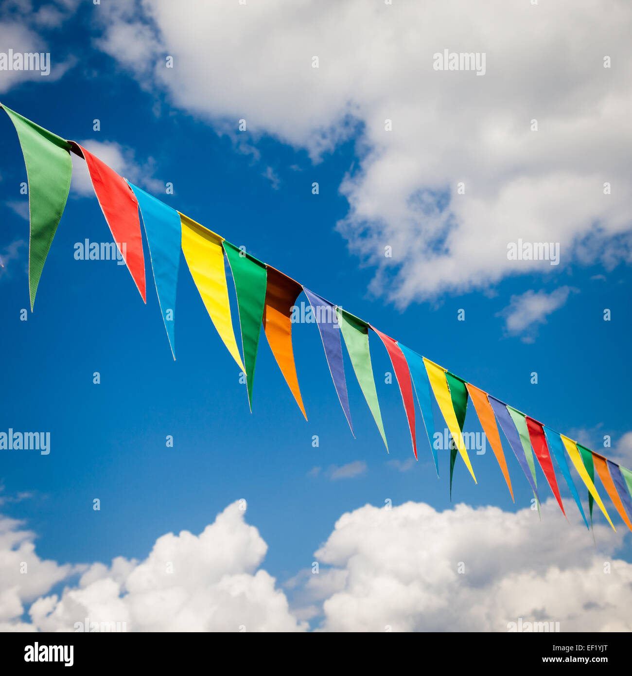 multi colored bunting triangular flags hanging on blue sky background ...