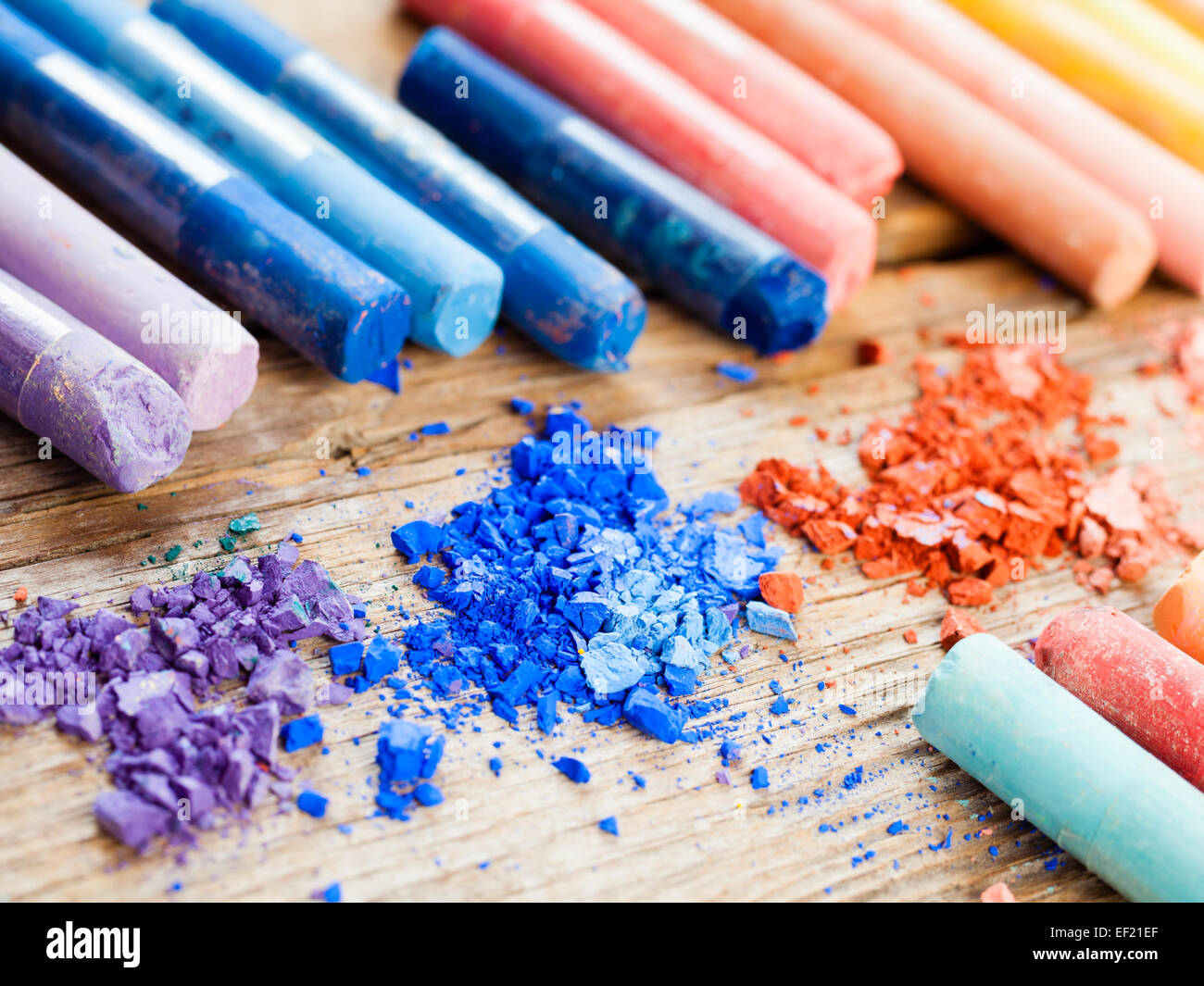Rainbow colored pastel crayons with crushed chalk close up on old ...