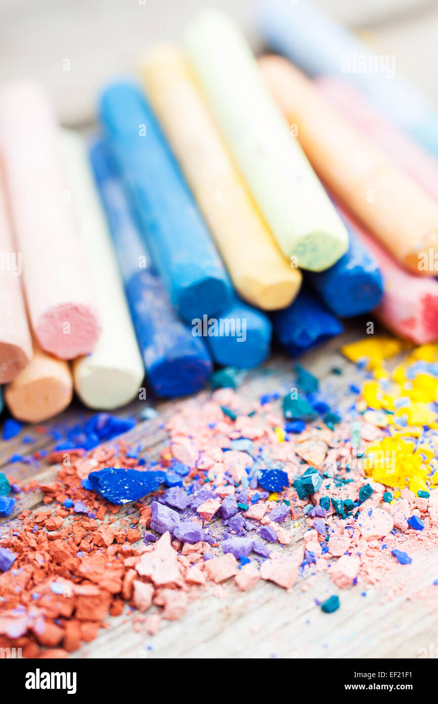 Pile of crushed chalk closeup and rainbow colored pastel crayons on ...