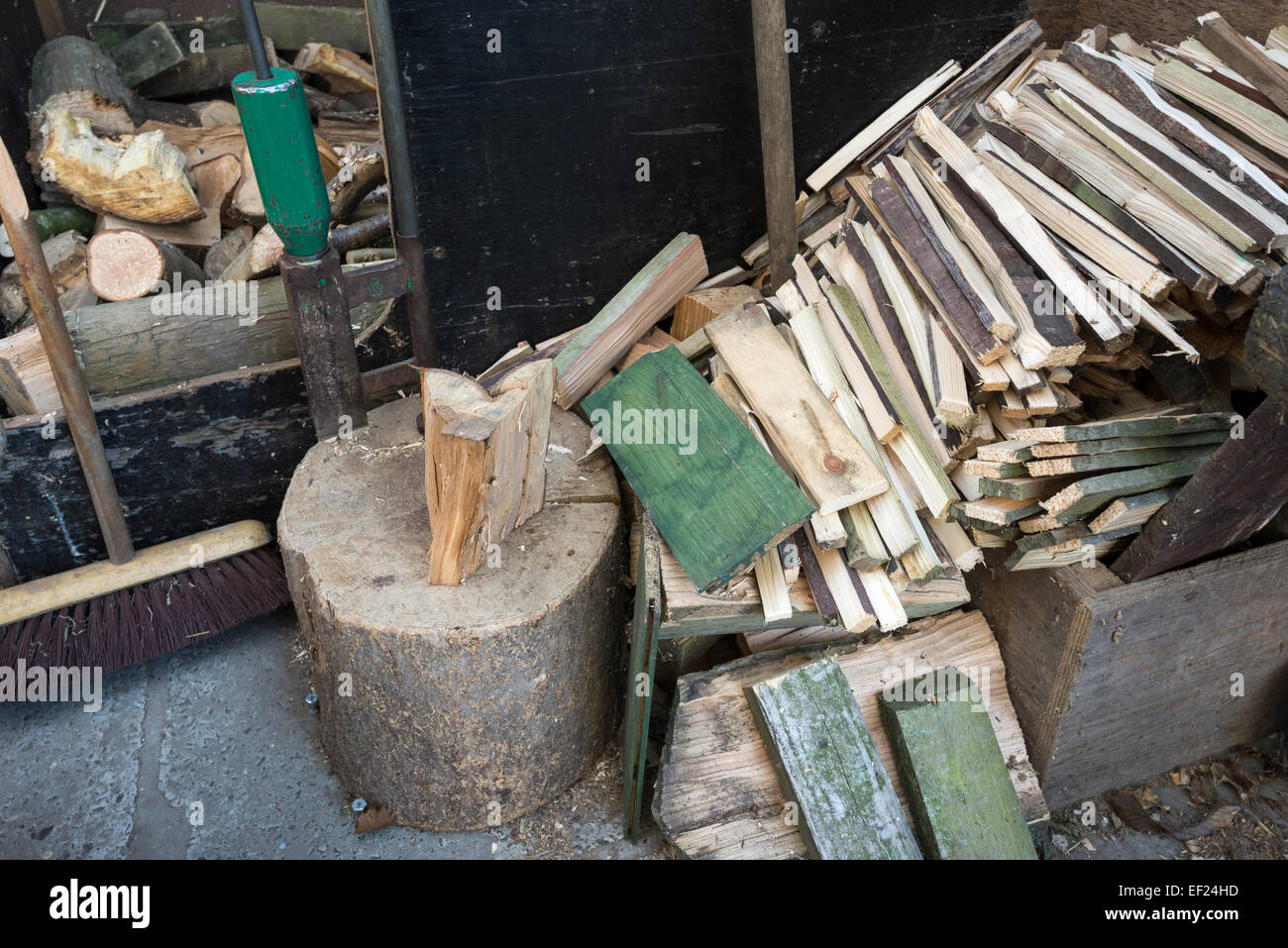 Wood splitter and pile of Kindling and logs in a wood store Stock Photo ...