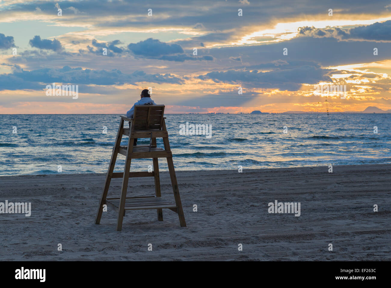 BENIDORM, SPAIN - JANUARY 21, 2015: Man on lifeguard chair on the beach ...