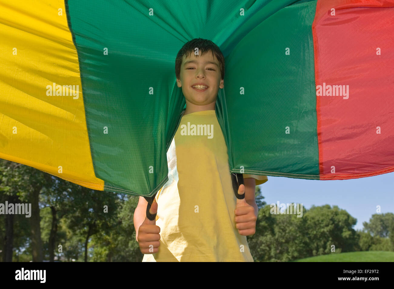 Boy standing under a parachute Stock Photo - Alamy