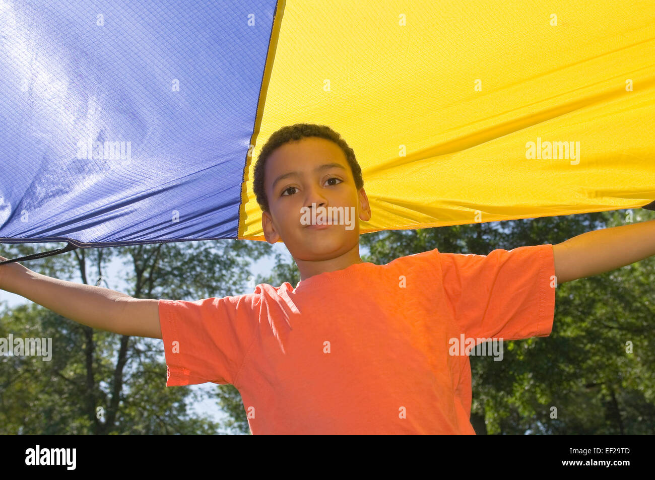 Boy standing under a parachute Stock Photo - Alamy
