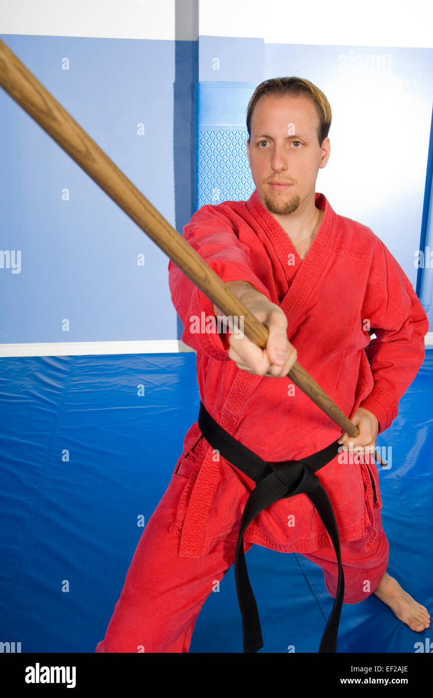 A man in a gym doing karate with a pole Stock Photo - Alamy