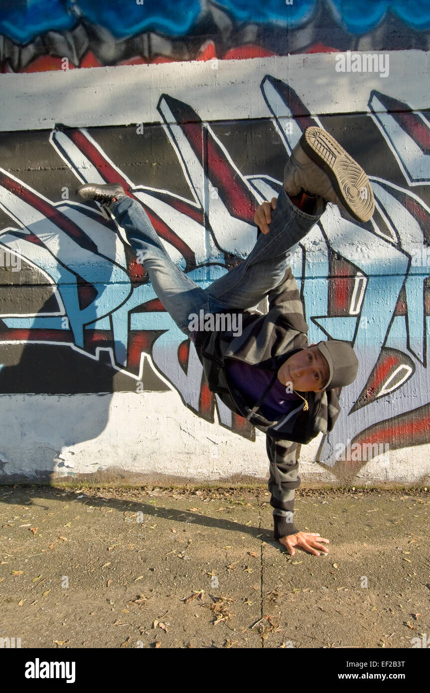 Teenage boy break dancing in front of wall of graffiti Stock Photo - Alamy