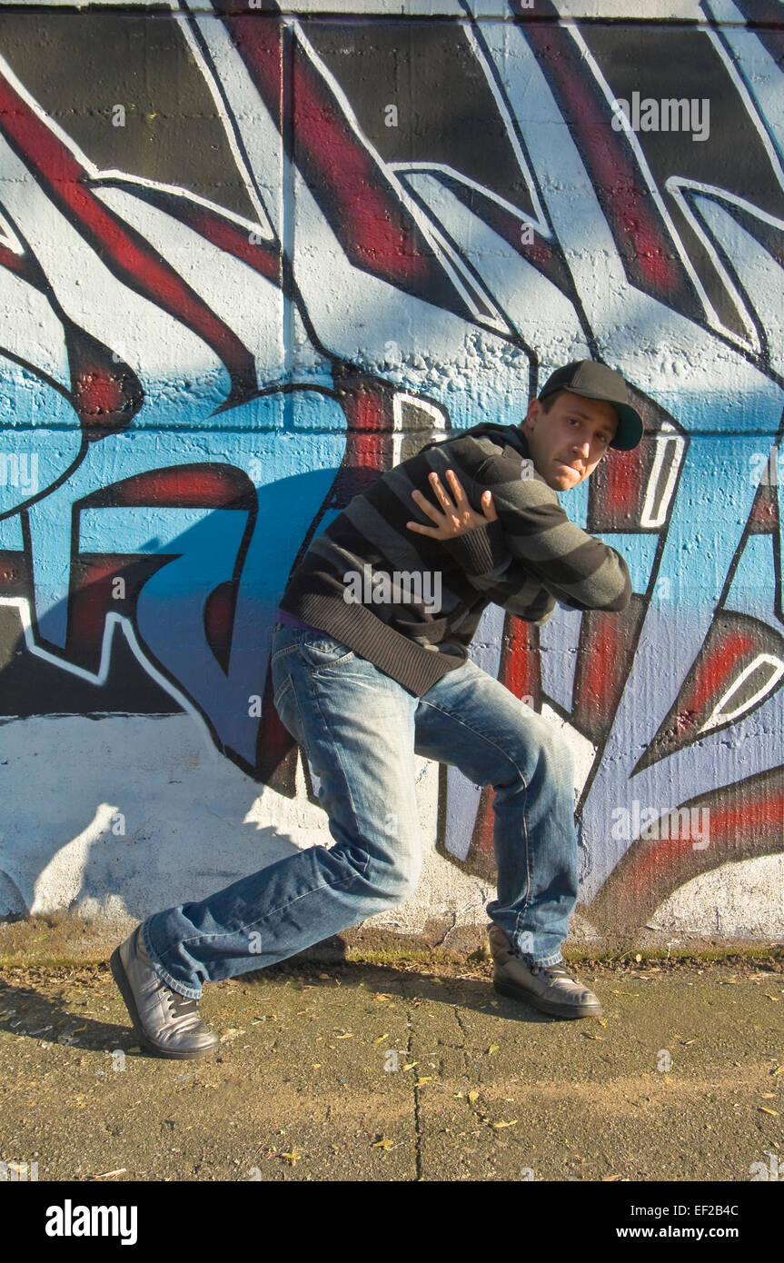 Teenage boy break dancing in front of wall of graffiti Stock Photo - Alamy