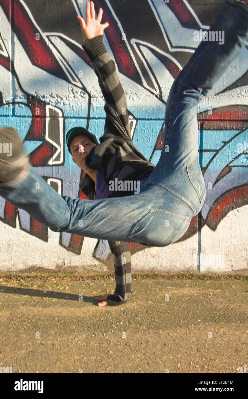 Teenage boy break dancing in front of wall of graffiti Stock Photo - Alamy
