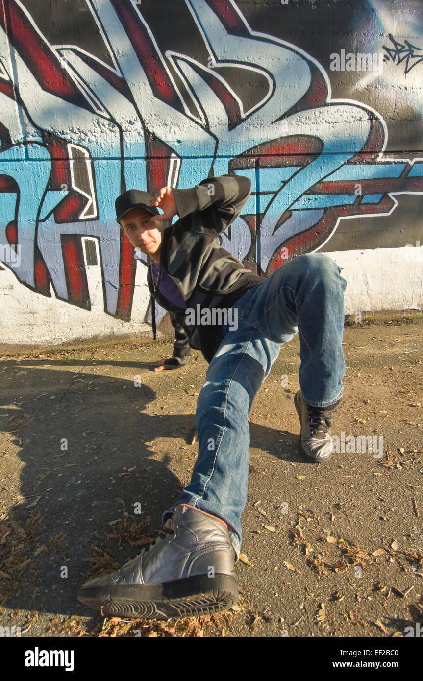 Teenage boy break dancing in front of wall of graffiti Stock Photo - Alamy