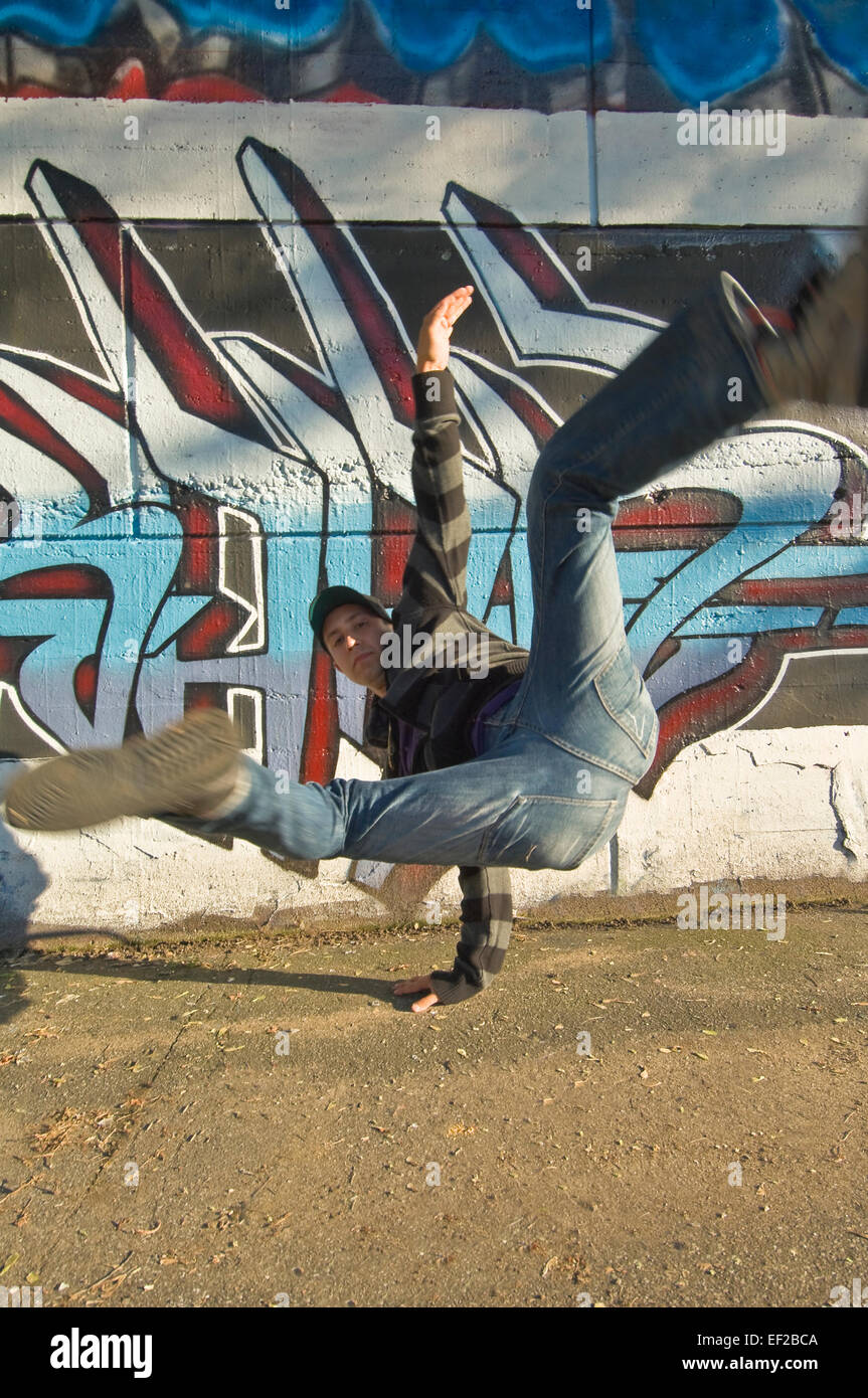 Teenage boy break dancing in front of wall of graffiti Stock Photo - Alamy