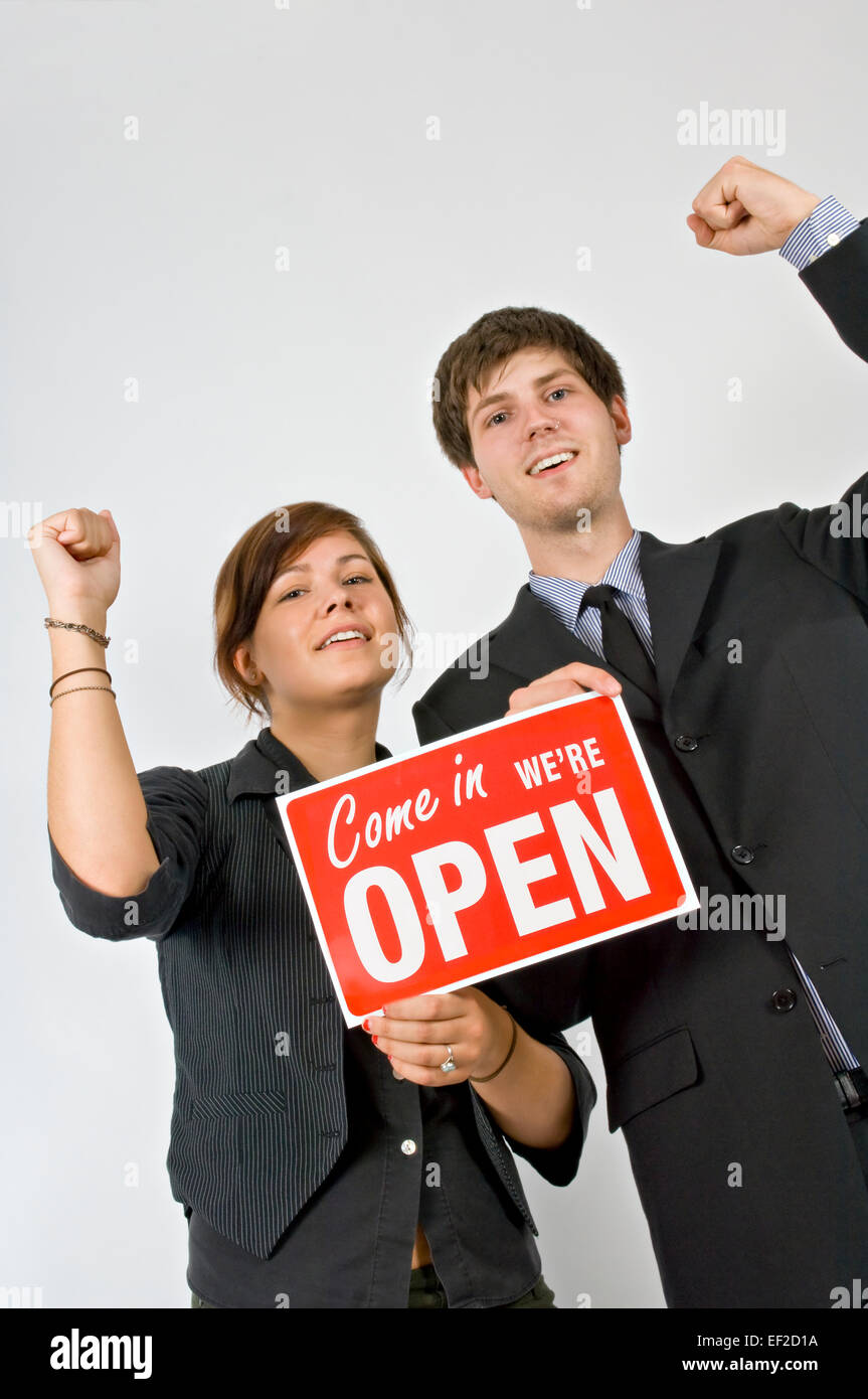 Two people holding an open sign Stock Photo - Alamy