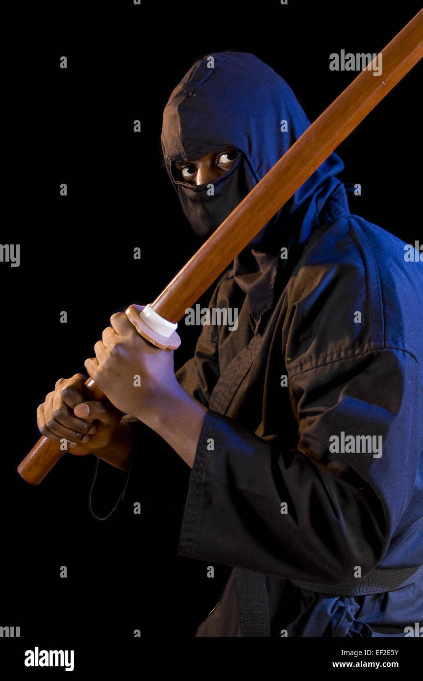Young man practicing karate in a ninja uniform with a pole Stock Photo ...