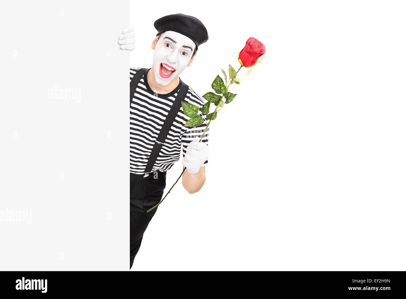 Mime artist holding a red rose behind a panel isolated on white ...