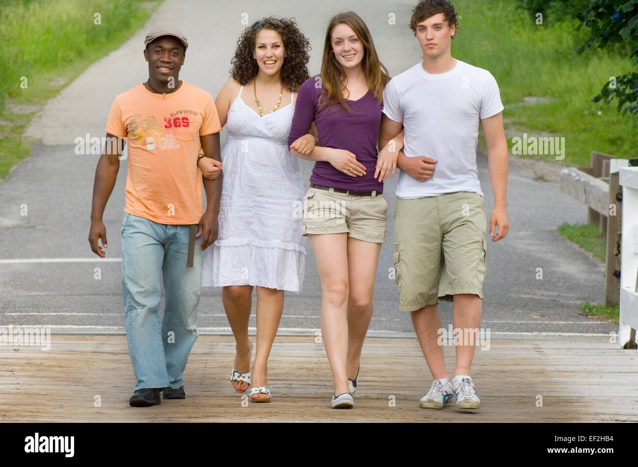 Four friends walking on a bridge Stock Photo - Alamy
