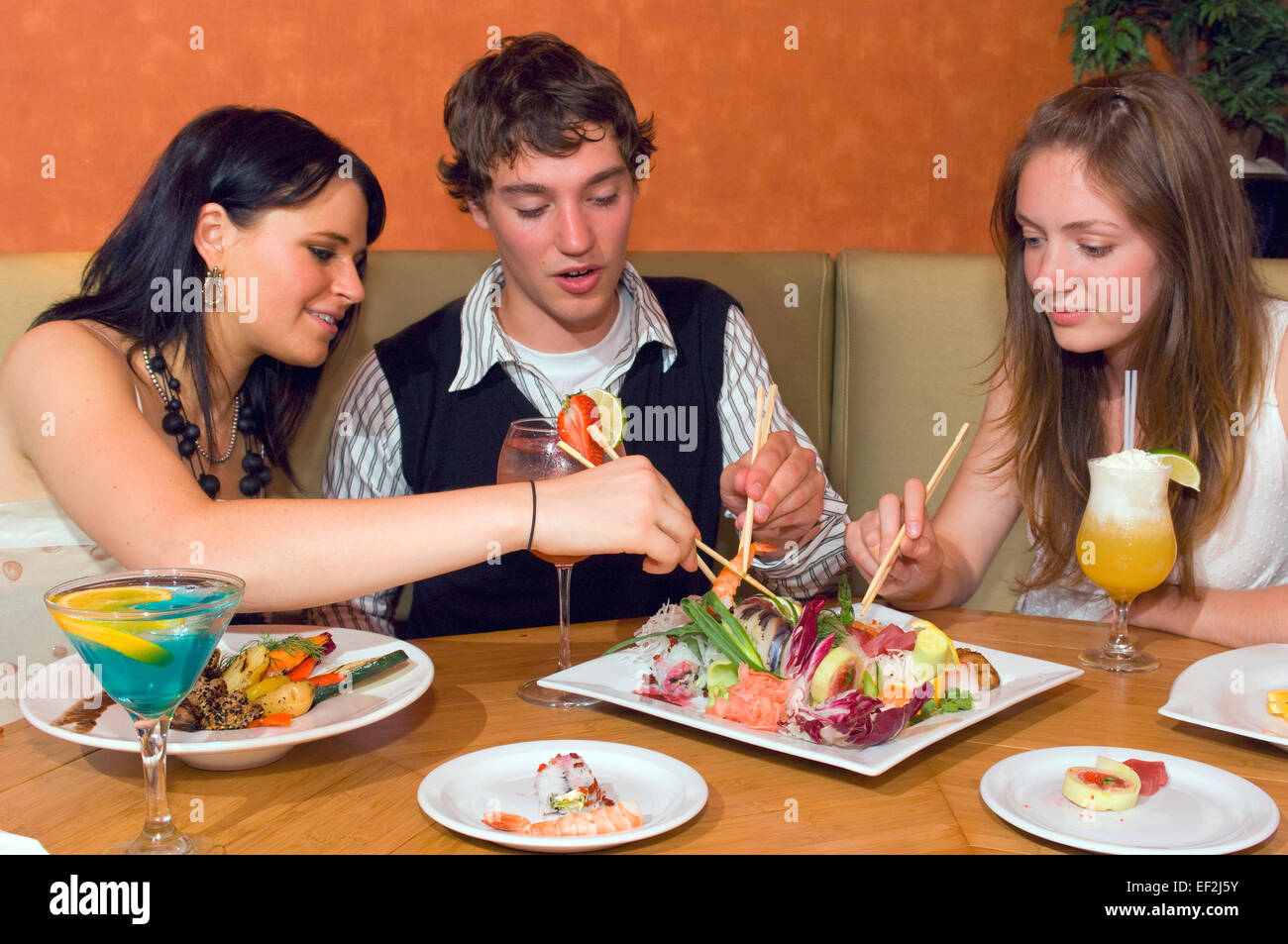 Three friends at a sushi restaurant Stock Photo - Alamy