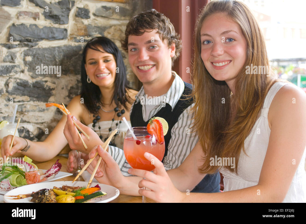 Three friends at a sushi restaurant Stock Photo - Alamy