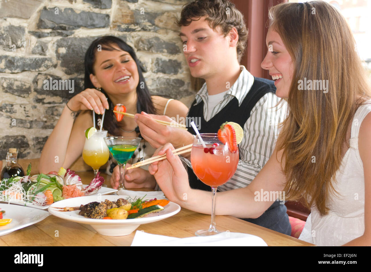 Three friends at a sushi restaurant Stock Photo - Alamy
