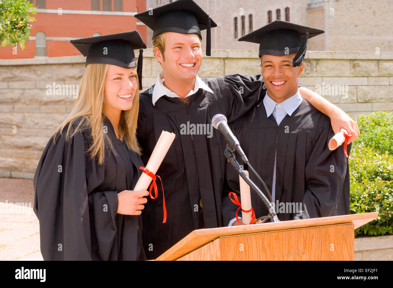 Three friends at a podium on graduation day Stock Photo - Alamy